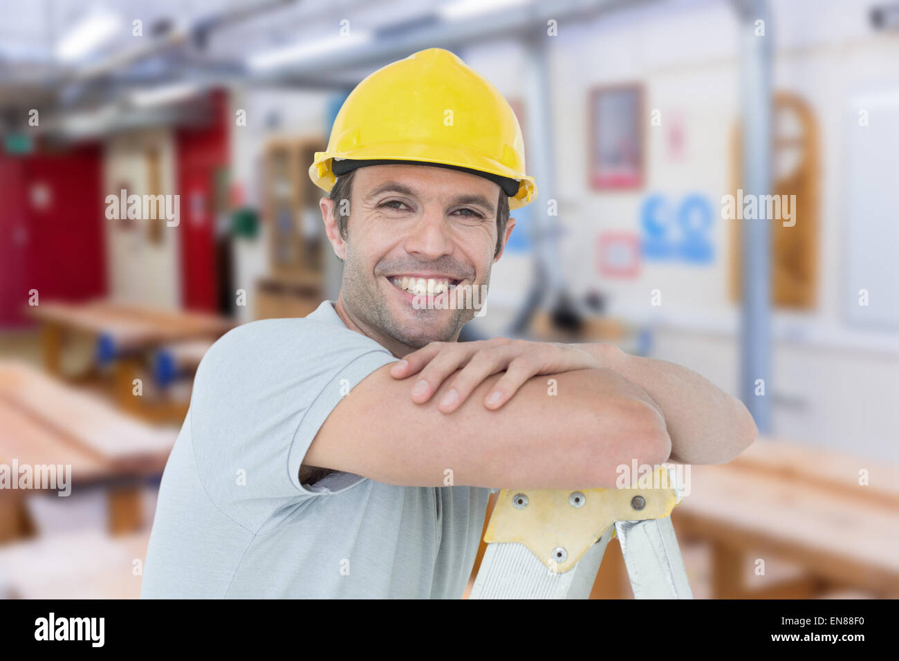 Composite image of happy technician leaning on step ladder Stock Photo ...