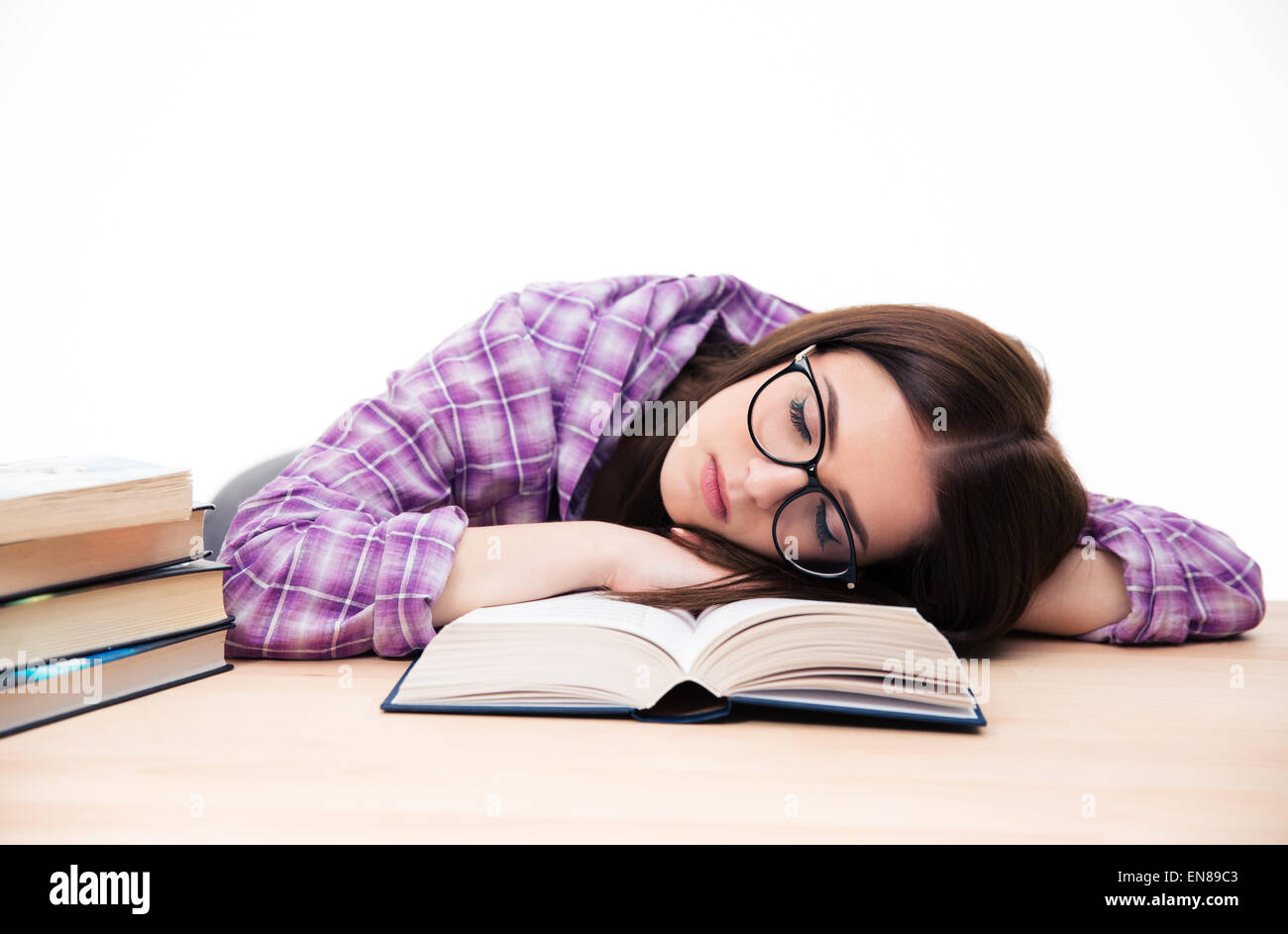 Young female student sleeping on the table with books over wihte ...