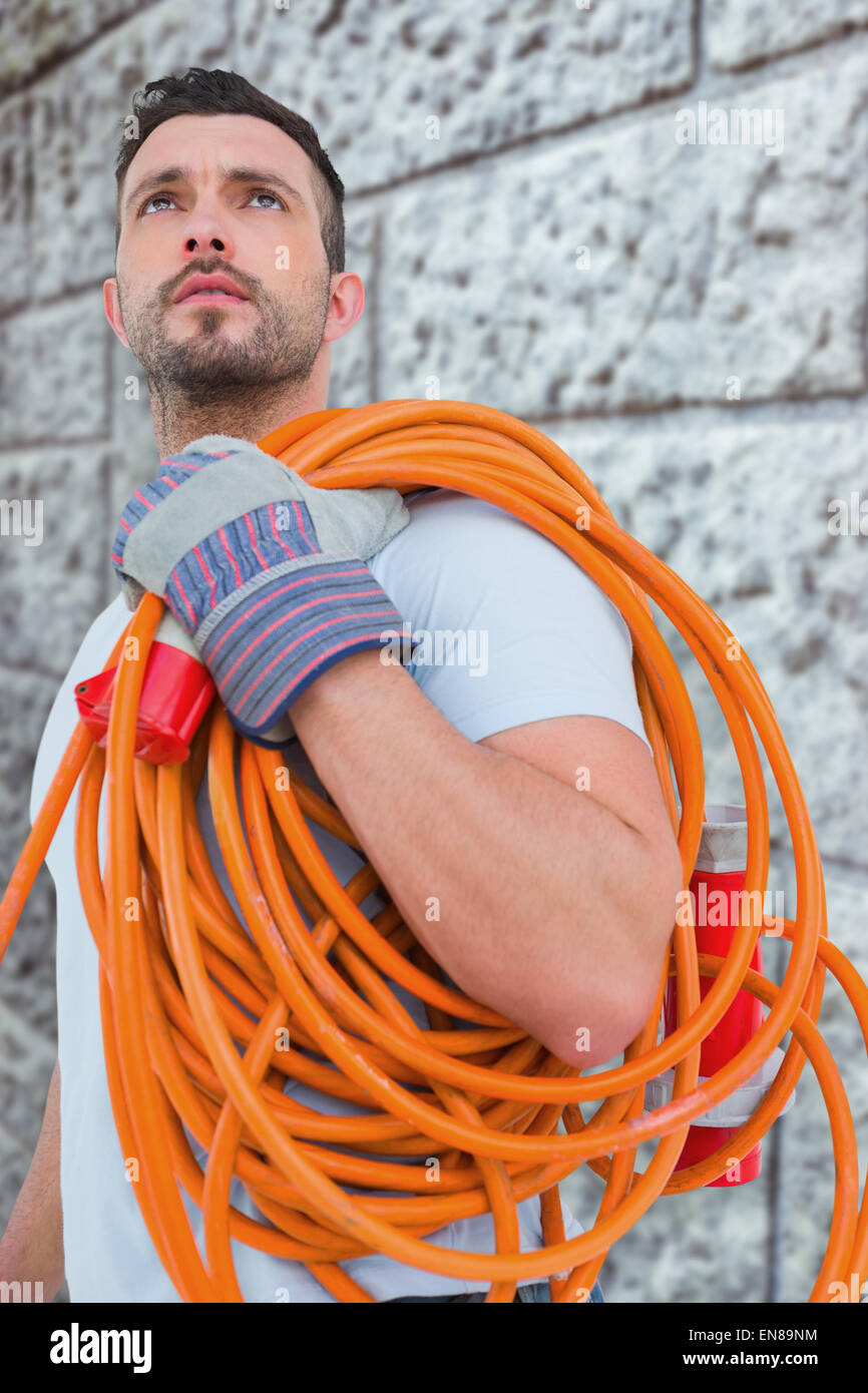 Composite image of repairman holding wire roll Stock Photo - Alamy