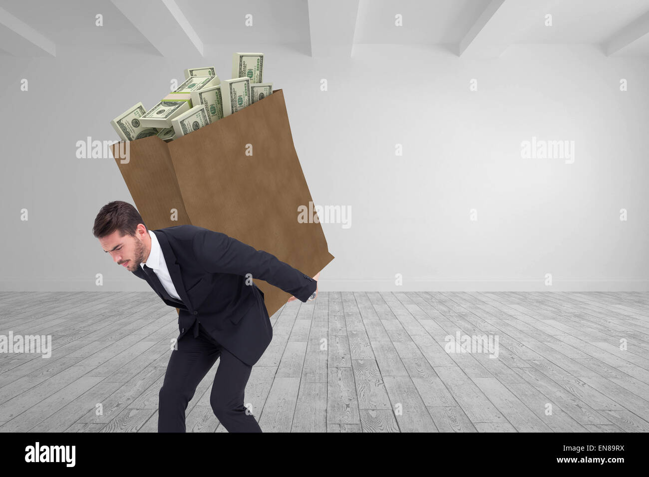 Composite image of businessman carrying something heavy with his back ...