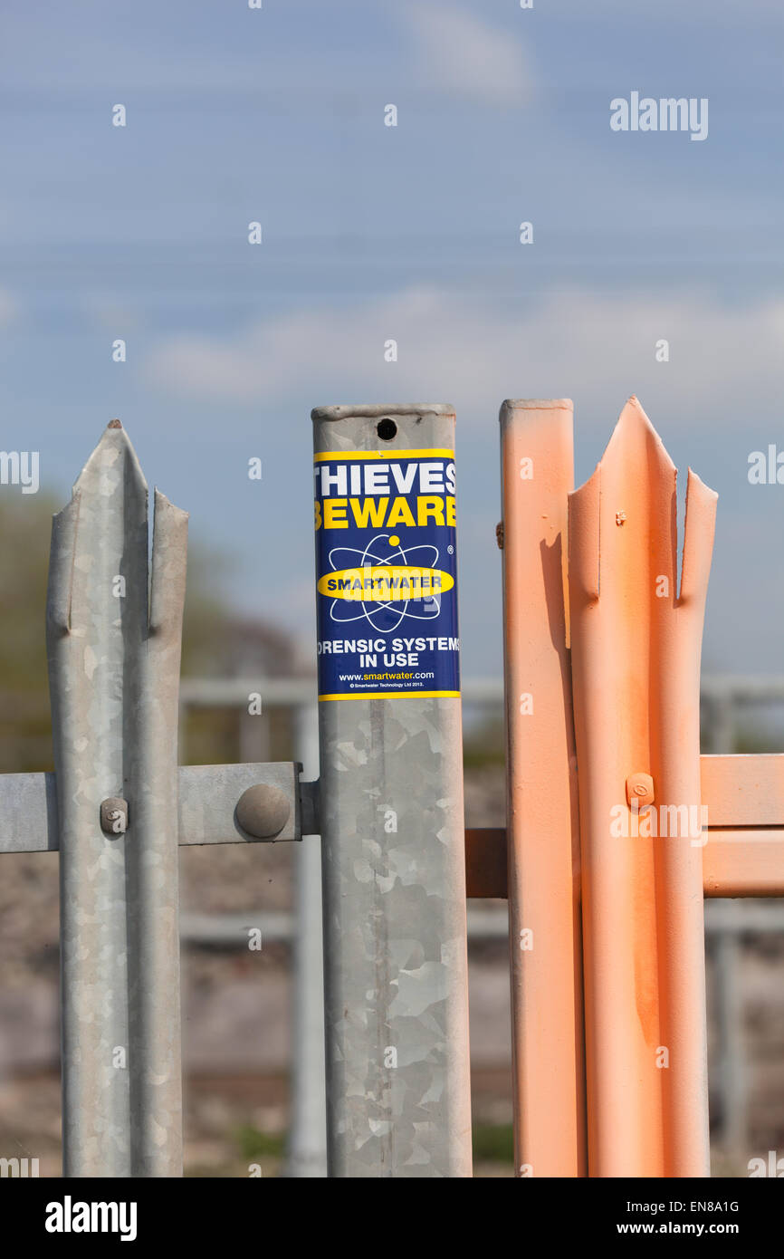 Smartwater forensic warning sticker on a gatepost along a railway line ...