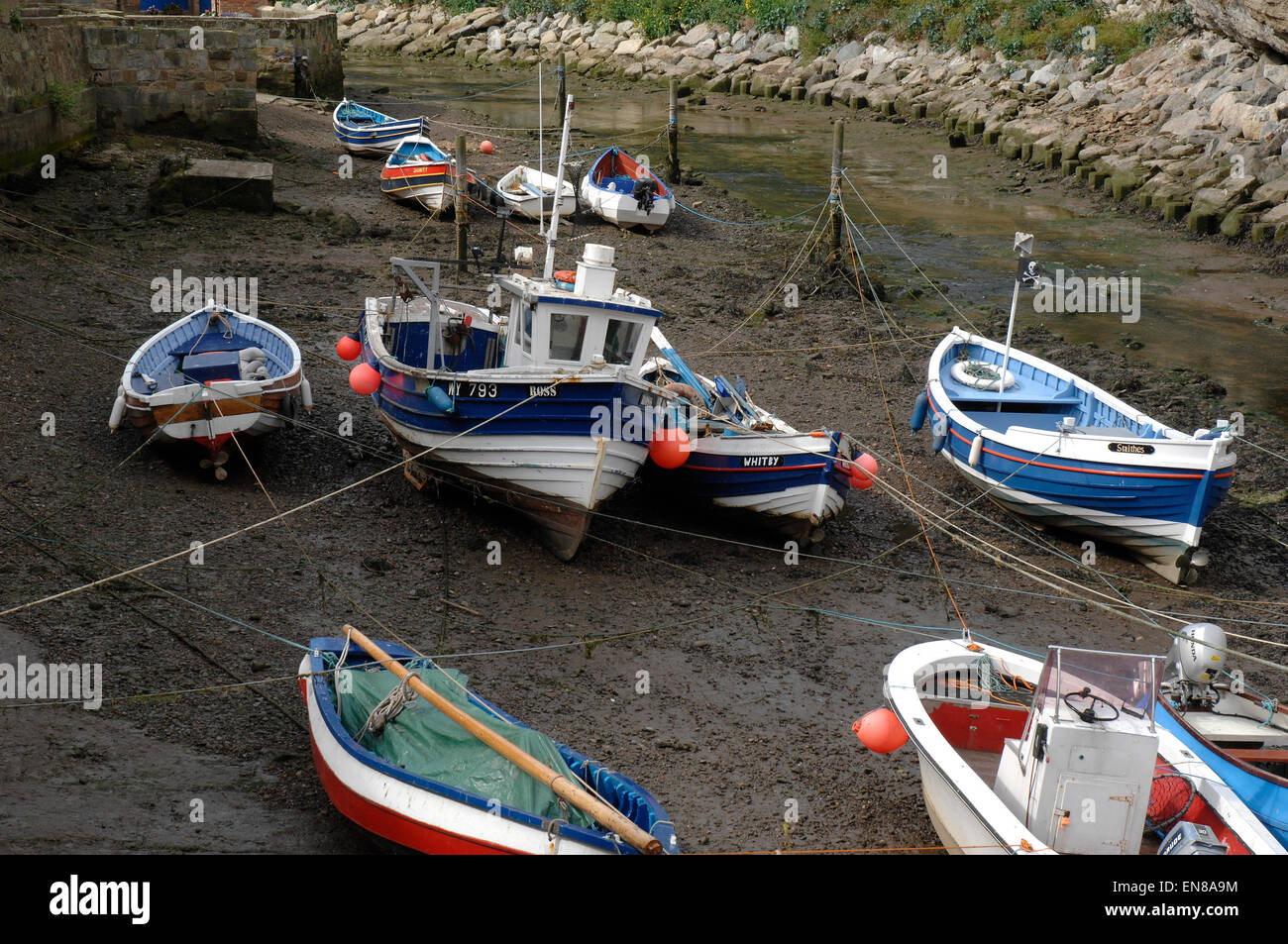 Staithes harbour in Yorkshire with moored fishing boats laying aground ...