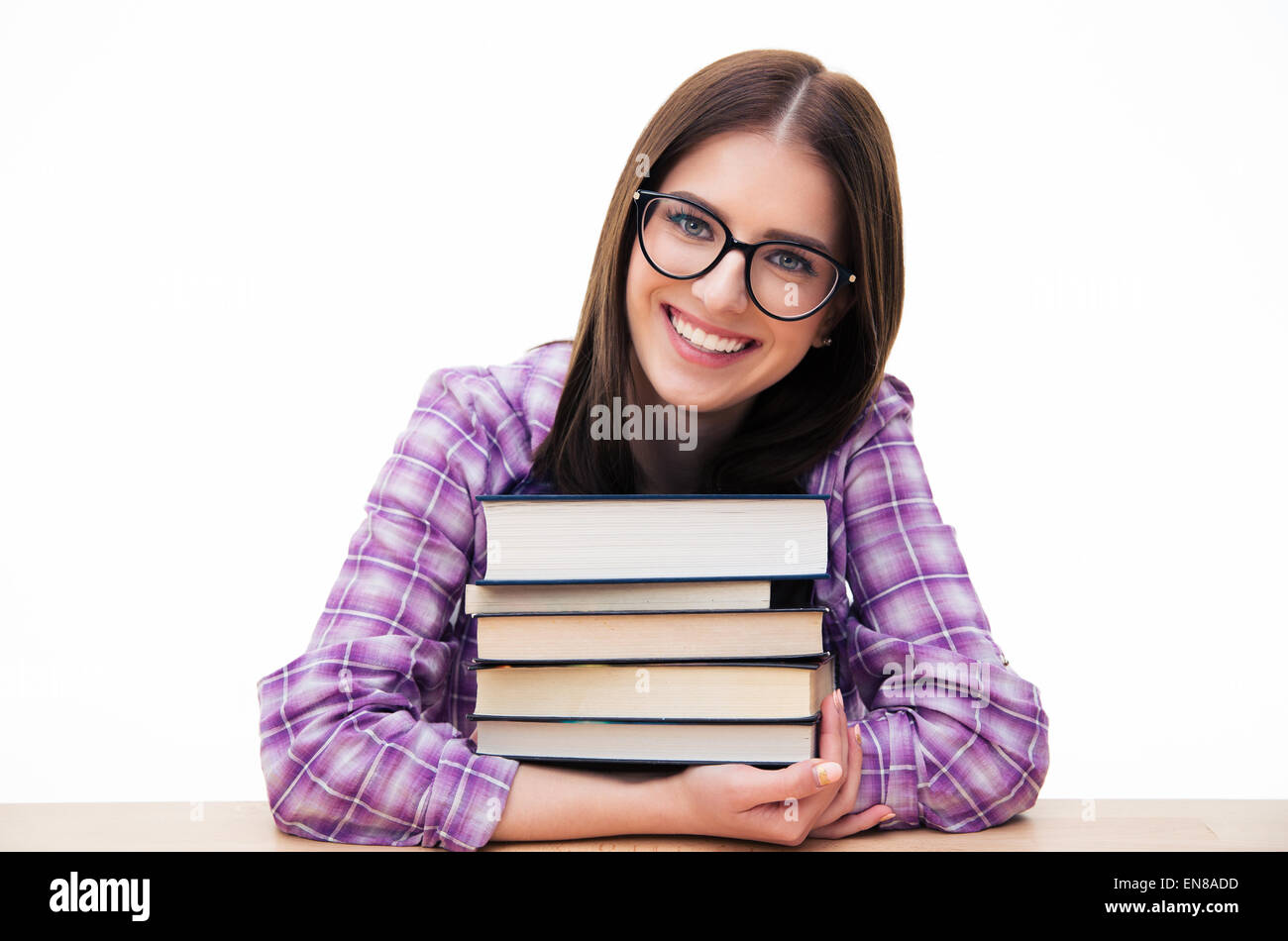 Happy young female student sitting at the table with books over white ...