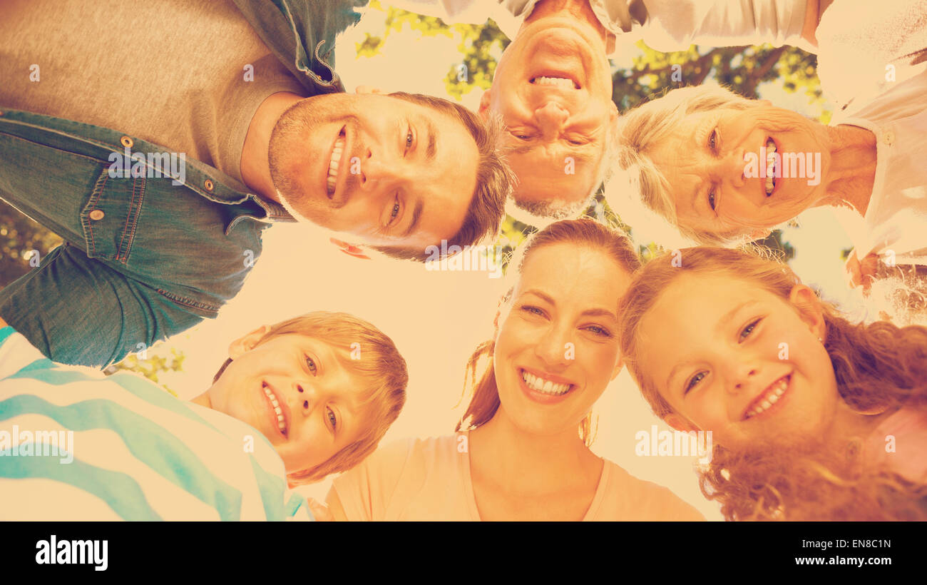 Extended family forming huddle in park Stock Photo - Alamy