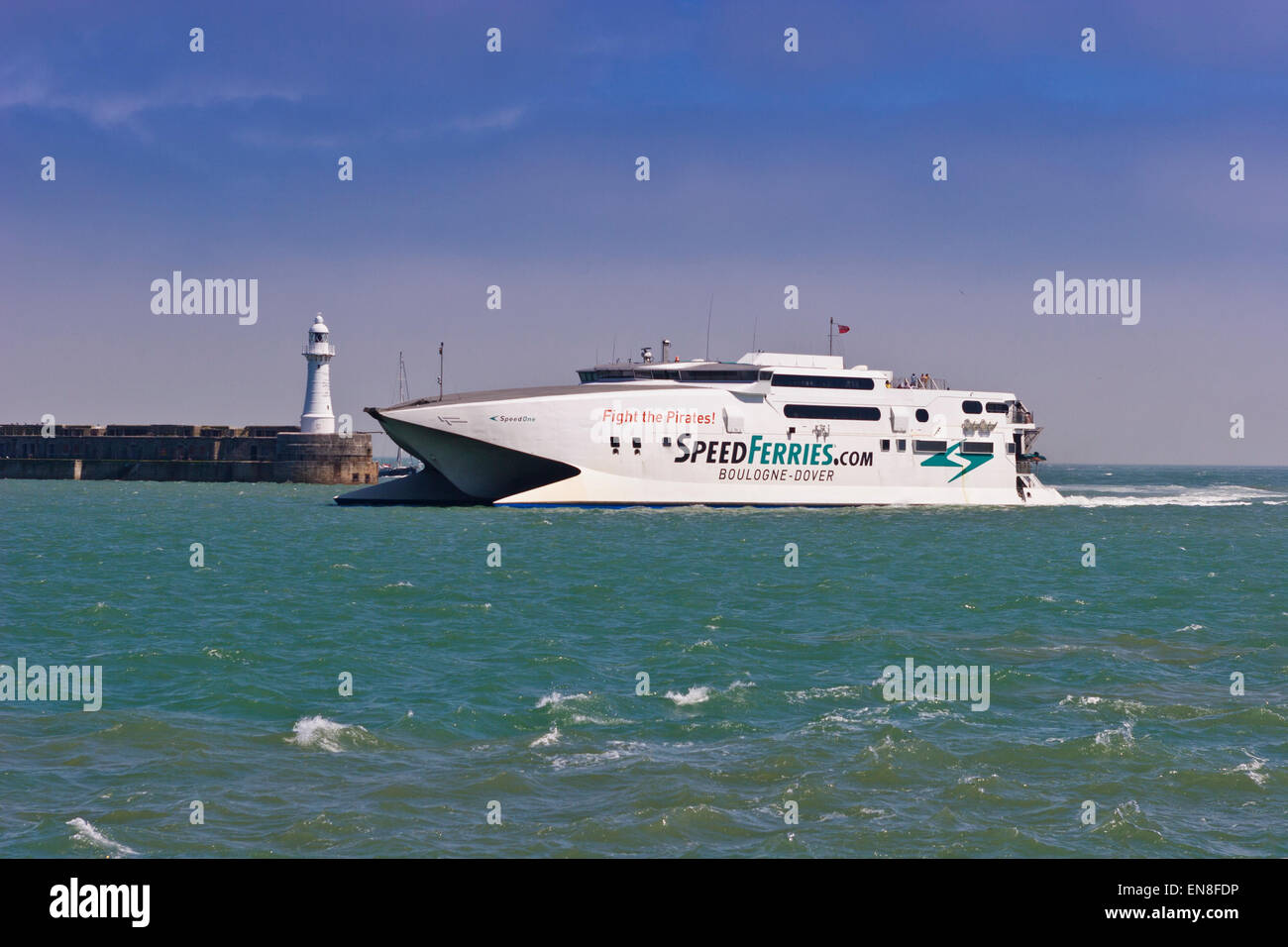 A speed ferry approaching Dover harbour with a white lighthouse in the ...