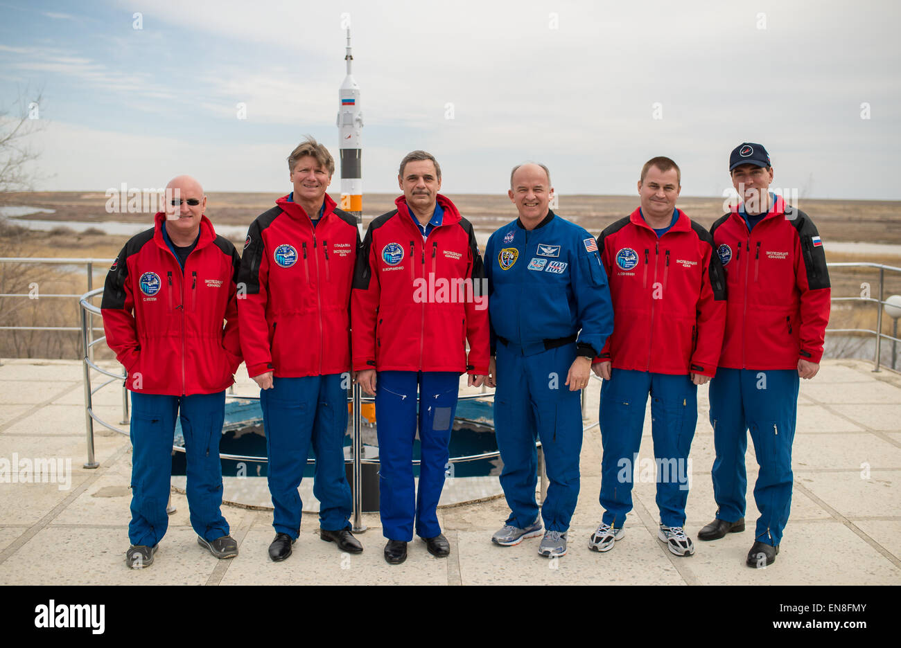 The crew of Expedition 43 poses near a Soyuz rocket model during media ...