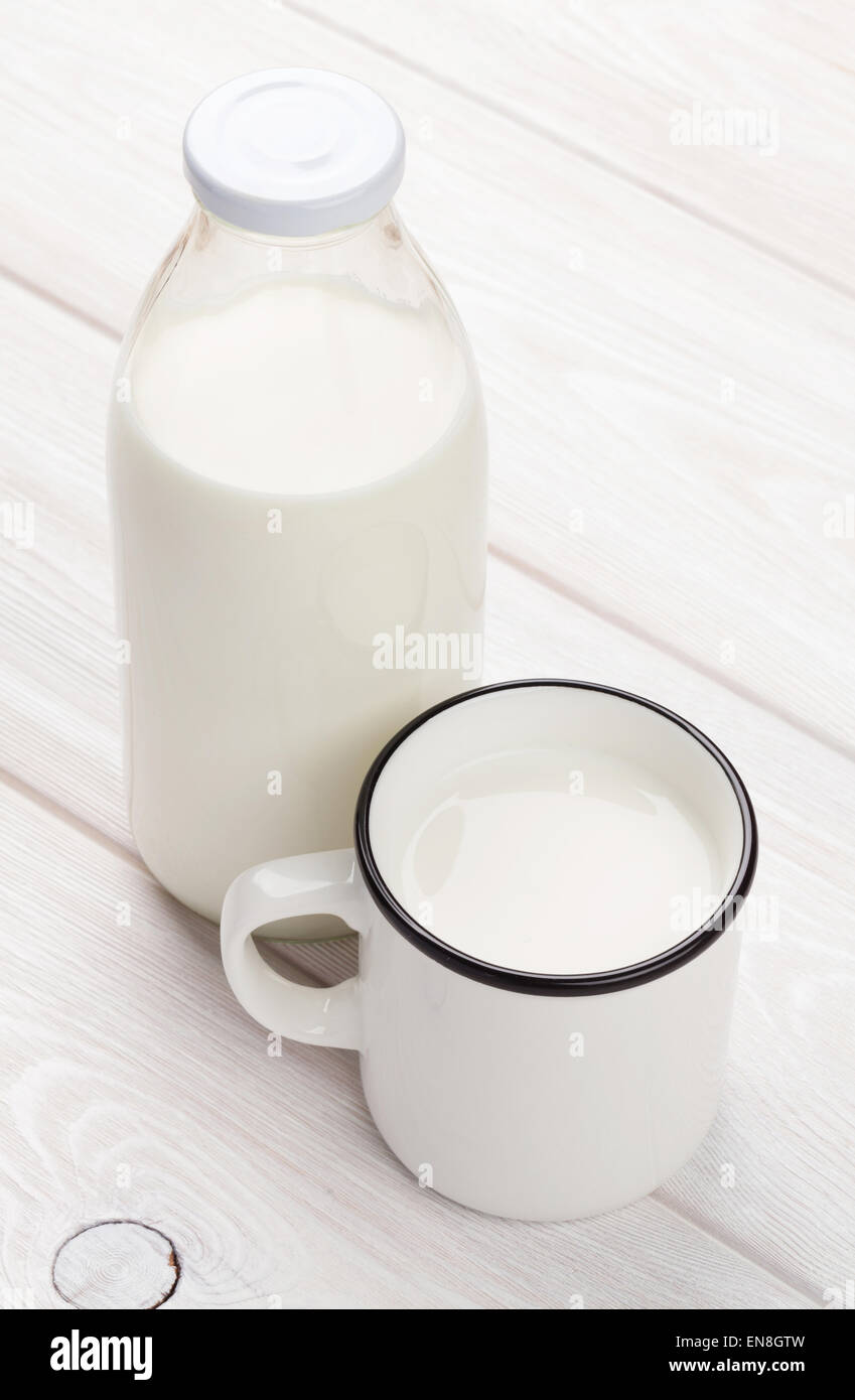 Milk cup and bottle on wooden table Stock Photo - Alamy