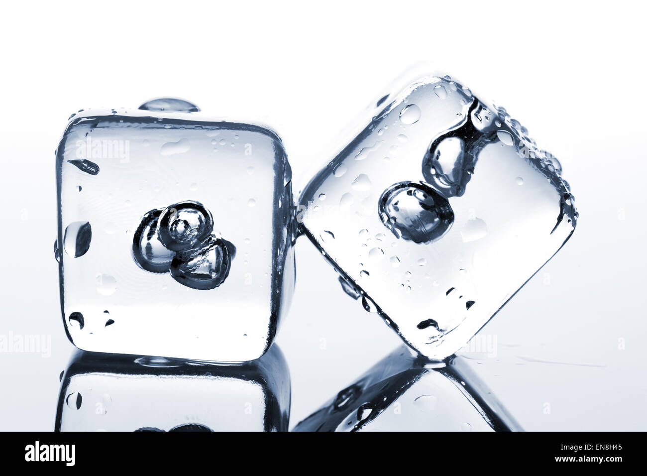 Two melting ice cubes with water dew on white background Stock Photo ...