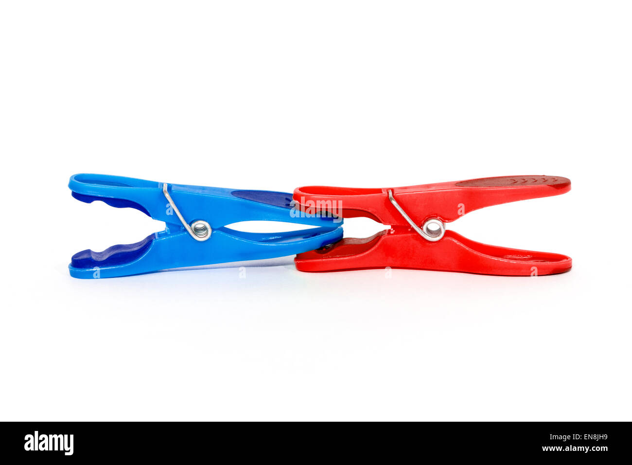 Red clothespin attacking blue clothespin on a white background Stock ...