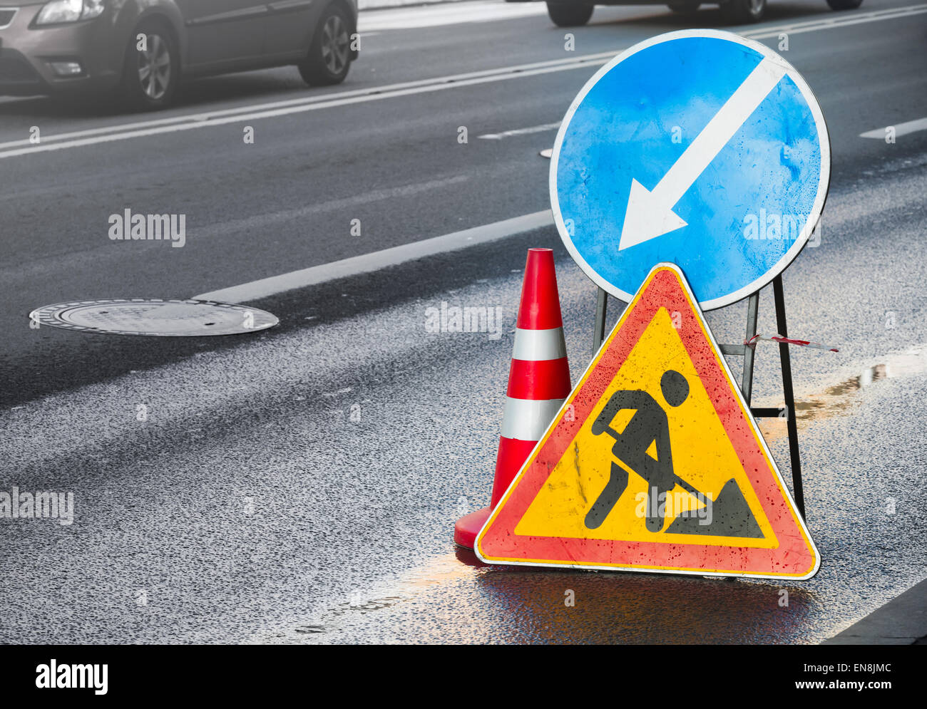 Roadsigns on the urban asphalt road. Men at work Stock Photo - Alamy