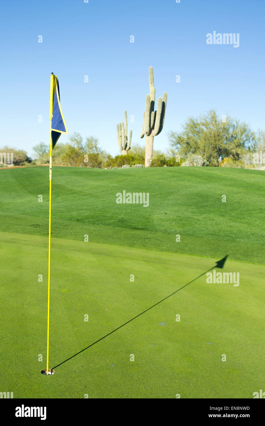 A golf hole and flag on the green of a golf course in the desert Stock ...