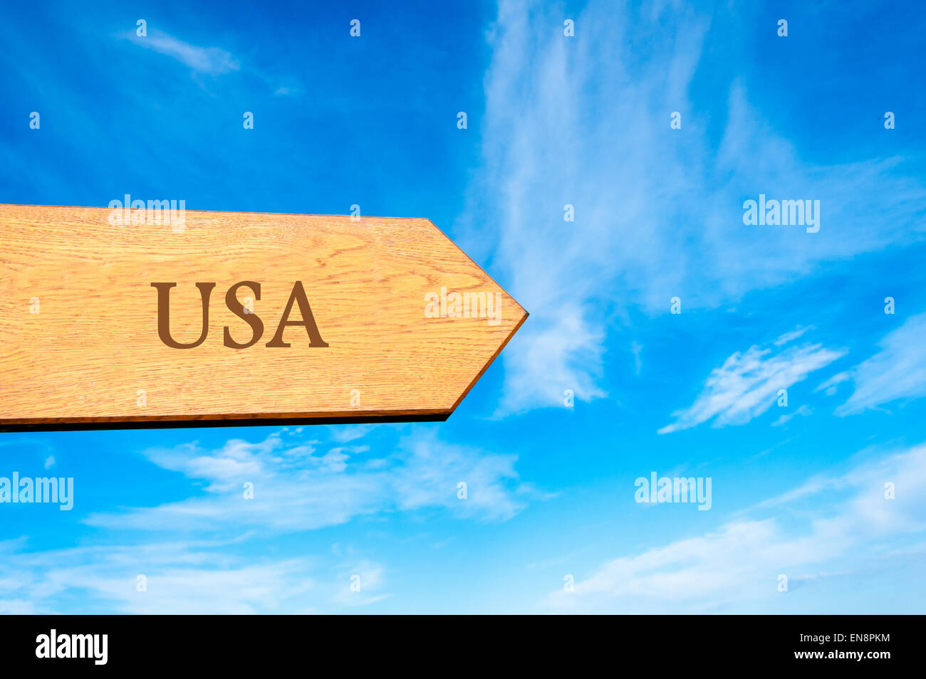 Wooden arrow sign pointing destination USA against clear blue sky with ...