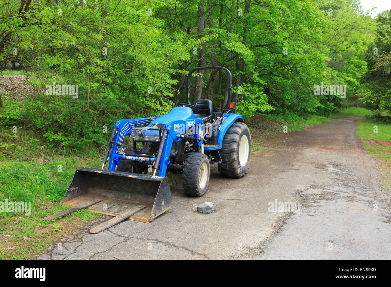 Blue Bush Hog TC400 tractor along a forest road Stock Photo - Alamy