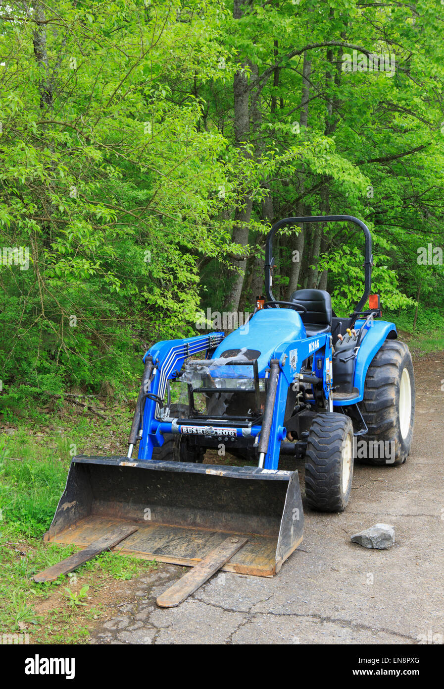 Blue Bush Hog TC400 tractor along a forest road Stock Photo - Alamy