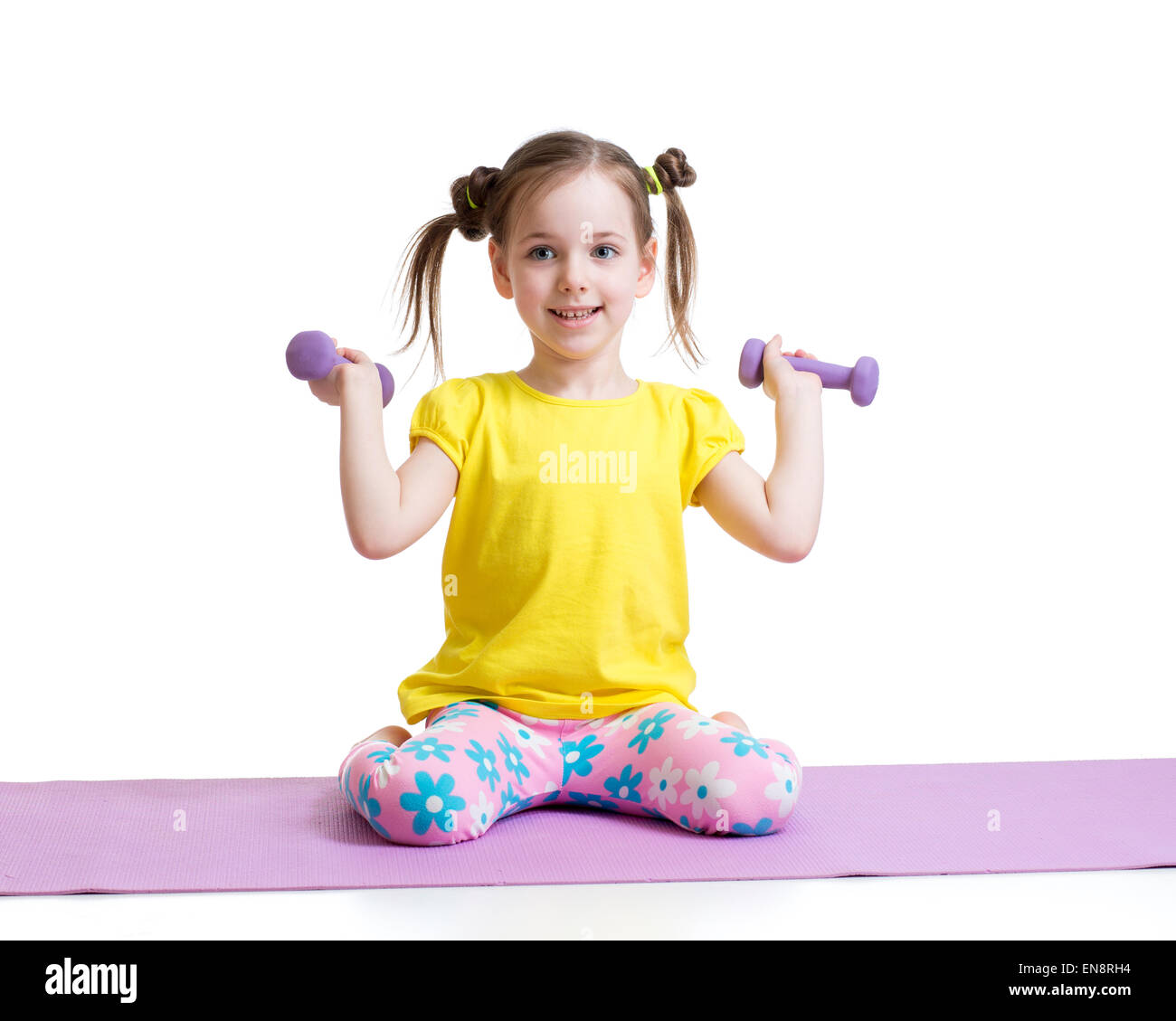 Active child girl doing fitness exercises isolated on white background ...