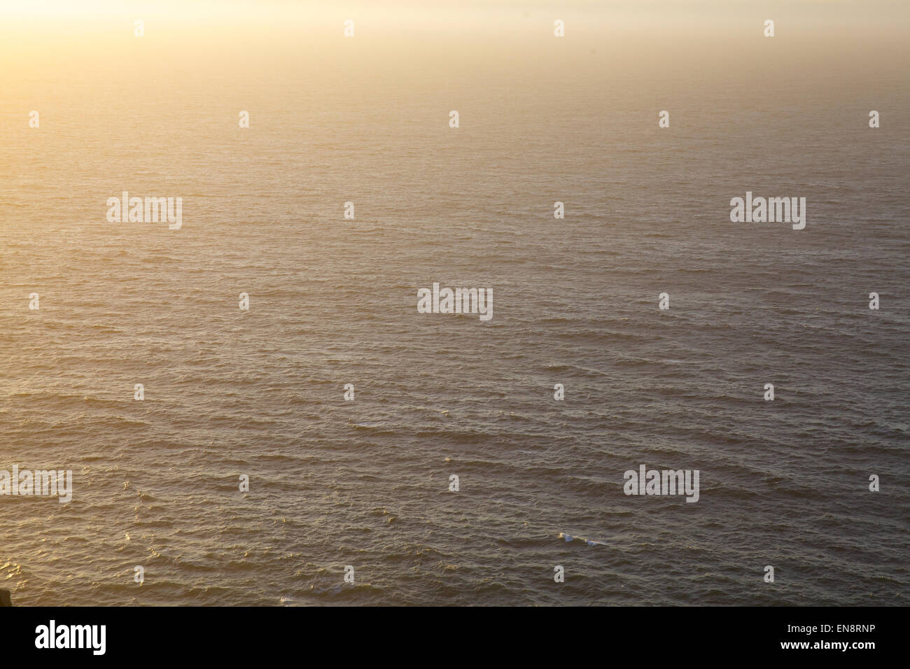 Warm hazy sunlight across a choppy, dark blue ocean Stock Photo - Alamy