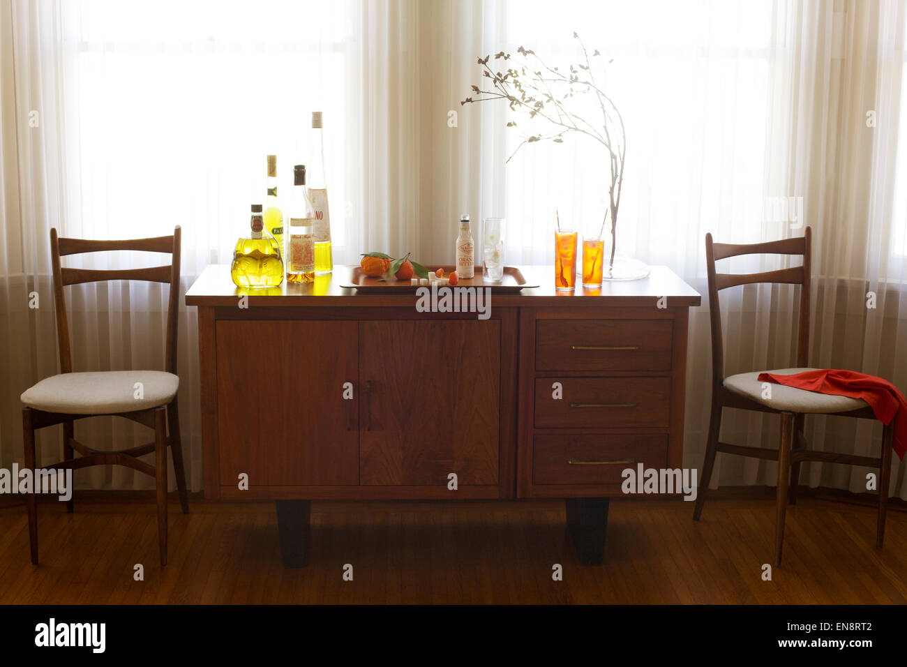 A home bar in front of a window with a bottles of liquor, oranges ...