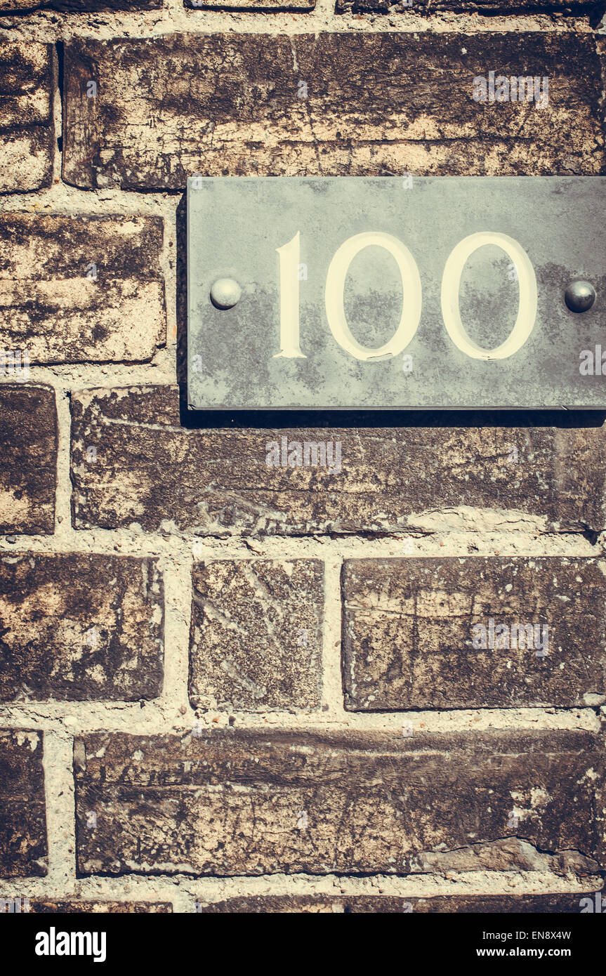 Weathered house number one hundred Stock Photo - Alamy
