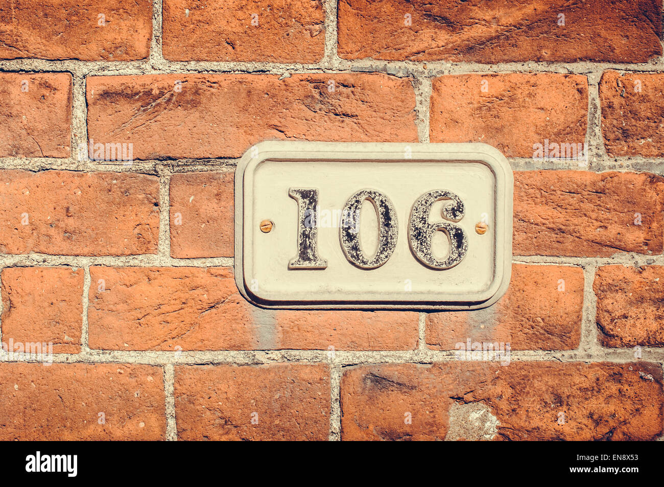 Weathered House number one hundred and six on a brick wall Stock Photo ...