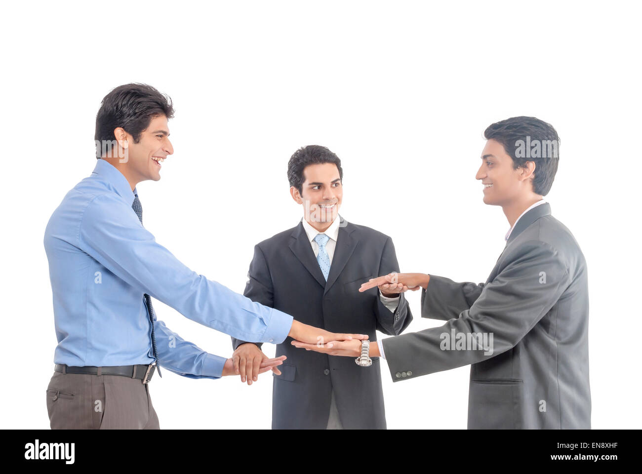 Three businessmen joining hands Stock Photo - Alamy