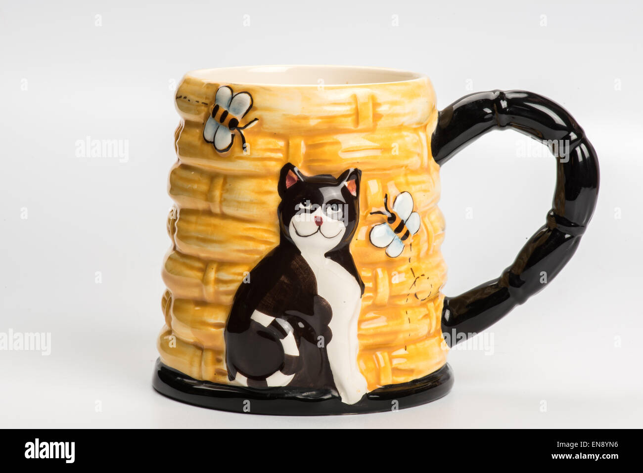 Yellow ceramic mug with cat on white background Stock Photo - Alamy