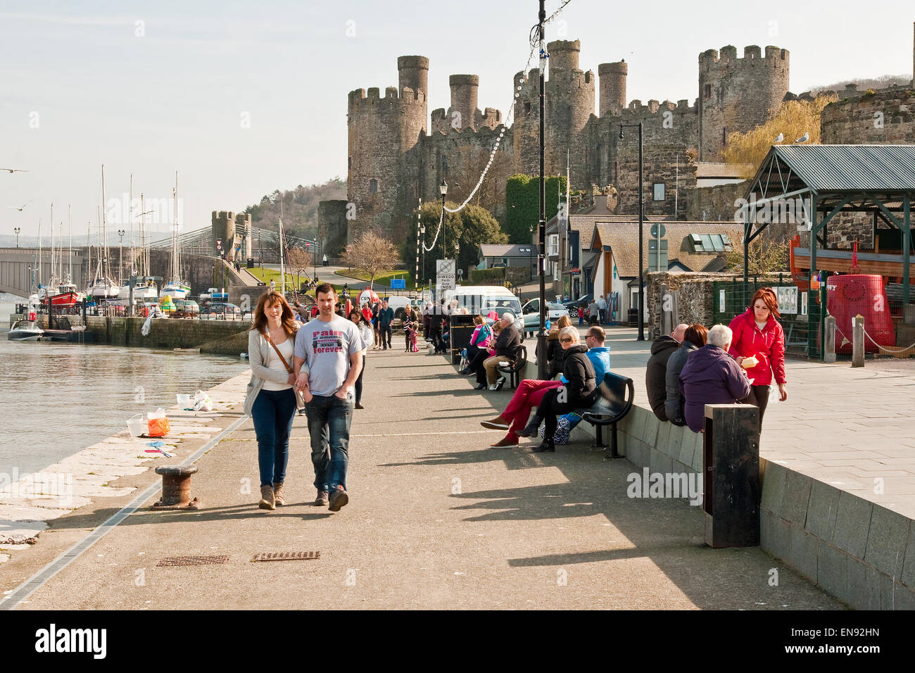 Visitors enjoying the Spring sunshine on Conwy Quay, with Conwy Castle ...