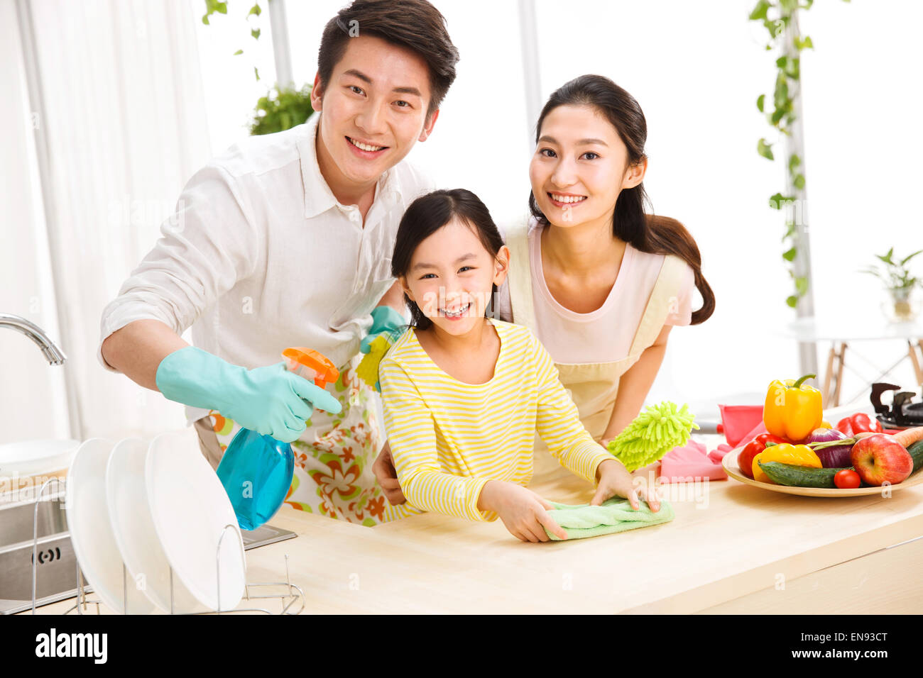Family doing cleaning-up in kitchen Stock Photo - Alamy