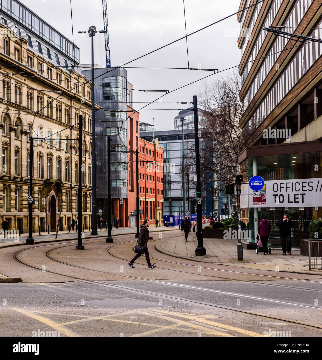 Man crossing tramlines in Manchester uk Stock Photo - Alamy