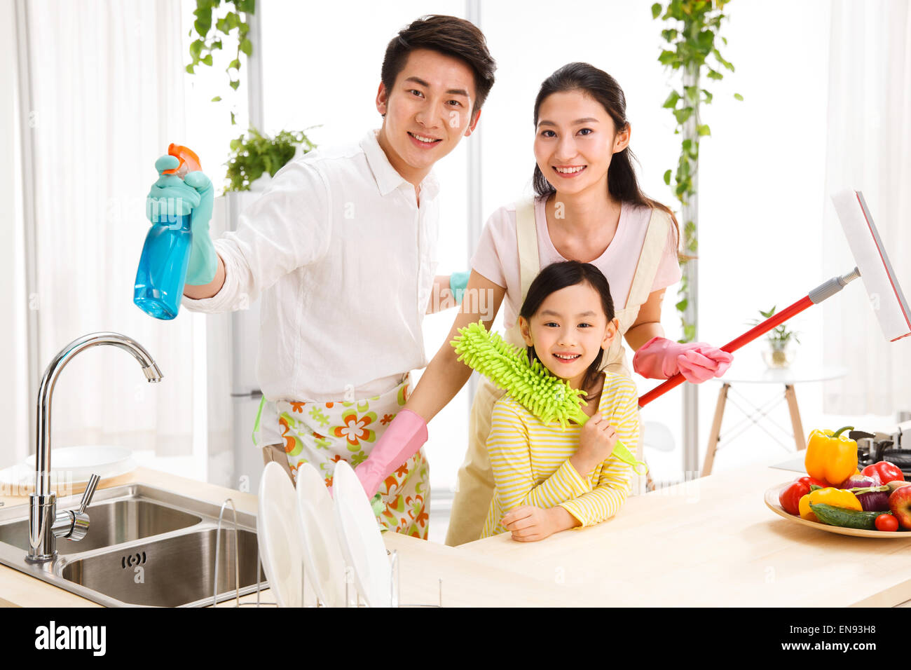 Family doing cleaning-up in kitchen Stock Photo - Alamy