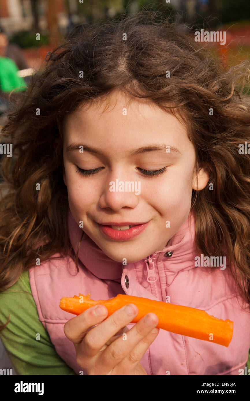 A young child eating a fresh carrot Stock Photo - Alamy