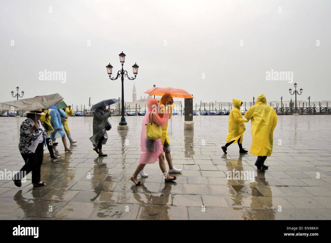 People with umbrellas and raincoats on a rainy day along Riva degli ...