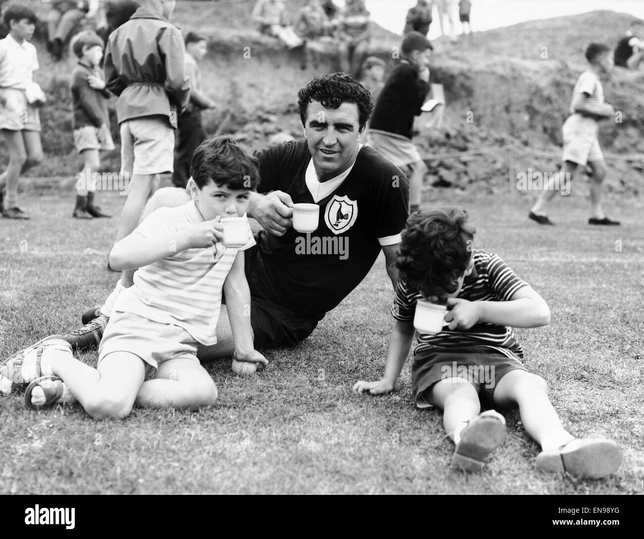 Bobby Smith of Tottenham Hotspur drinking a cup of tea with two young ...
