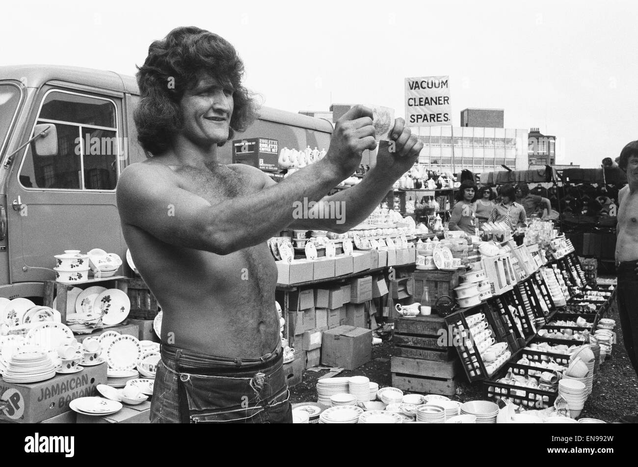 Bare chested Alan Dobbs who runs a pottery stall in London's Club Row ...