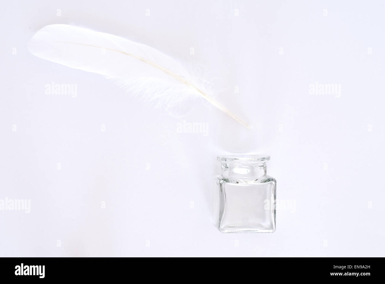 White feather on white background and ink pot Stock Photo - Alamy