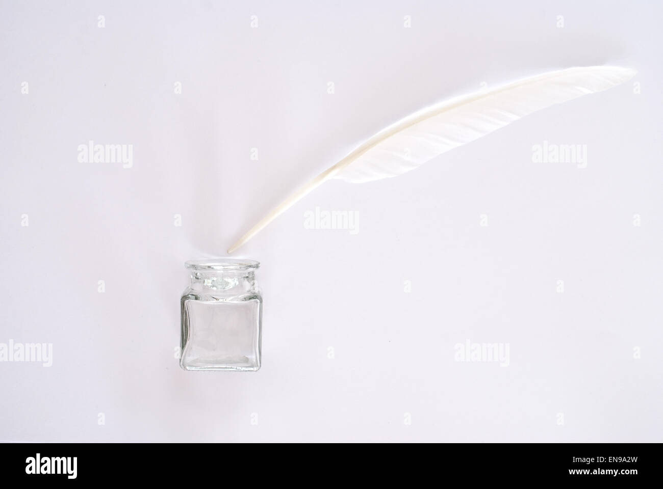 White feather on white background and ink pot Stock Photo - Alamy