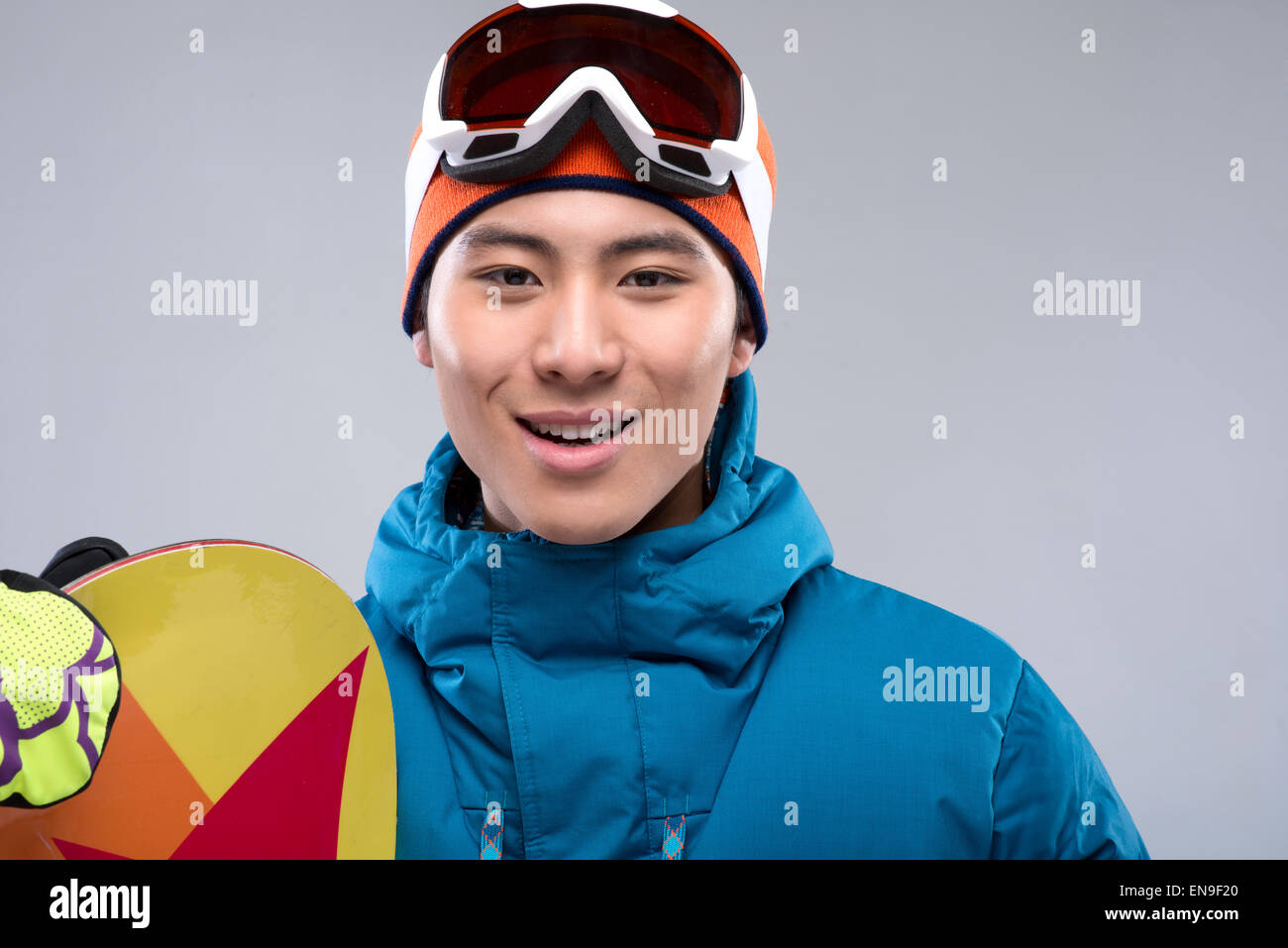 Portrait of a young man holding a snowboard looking at camera Stock ...