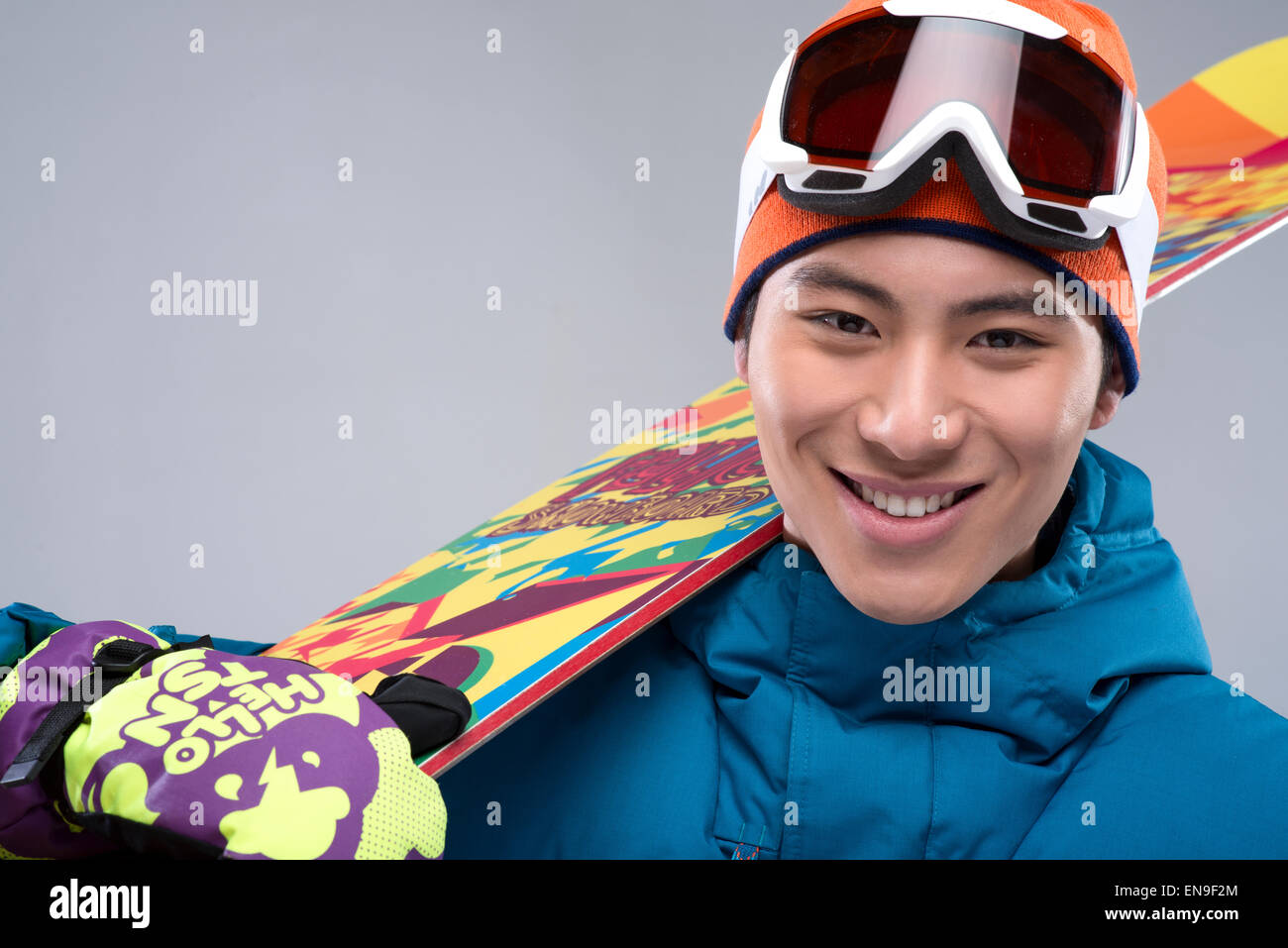 Young man with ski on shoulder smiling Stock Photo - Alamy
