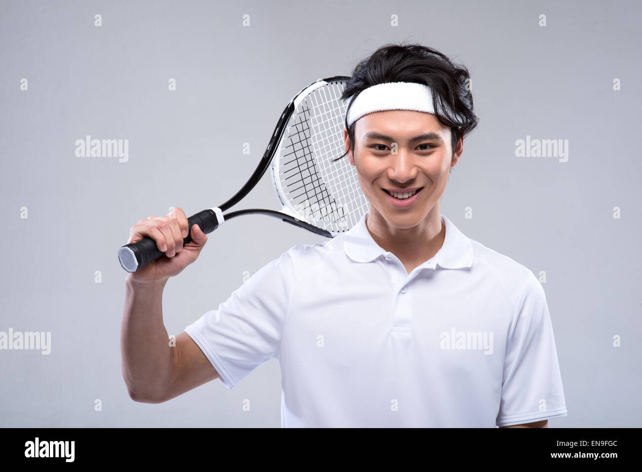 Young man holding tennis racquet on shoulders Stock Photo - Alamy