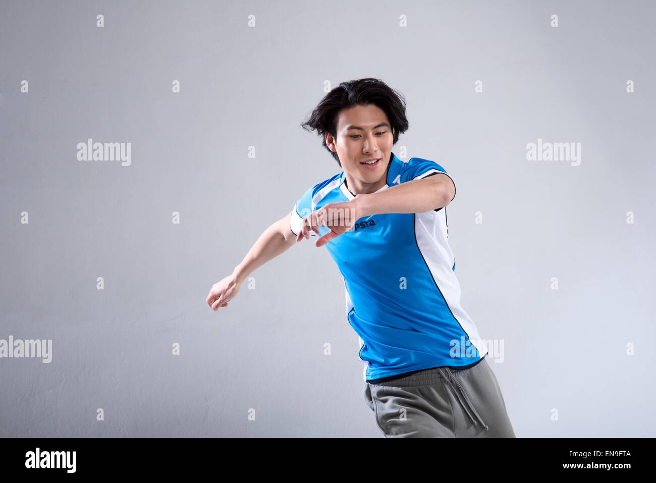 Young man kicking football Stock Photo - Alamy