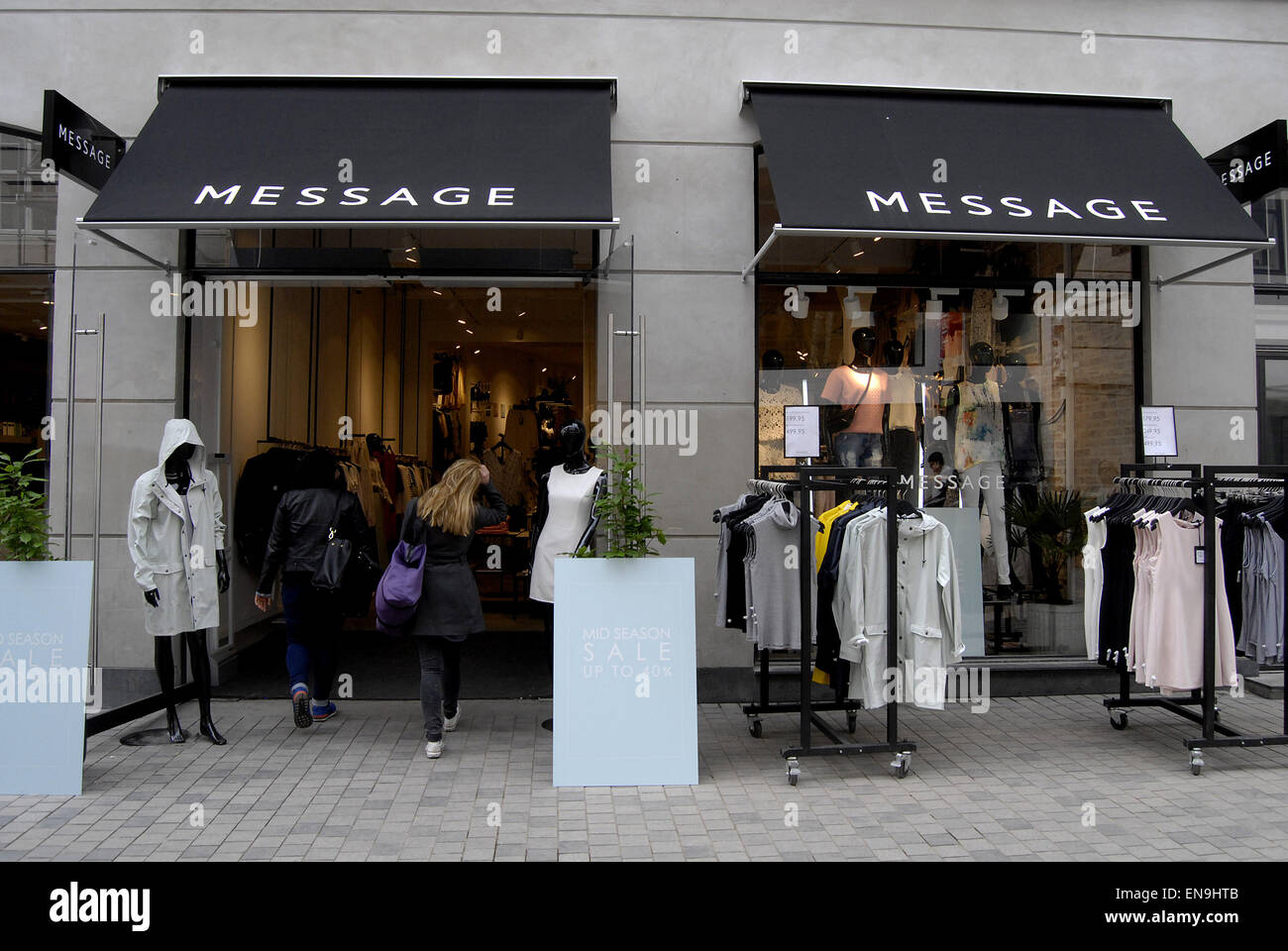 Copenhagen, Denmark. 30th April, 2015. Shoppers walk by store ads with ...