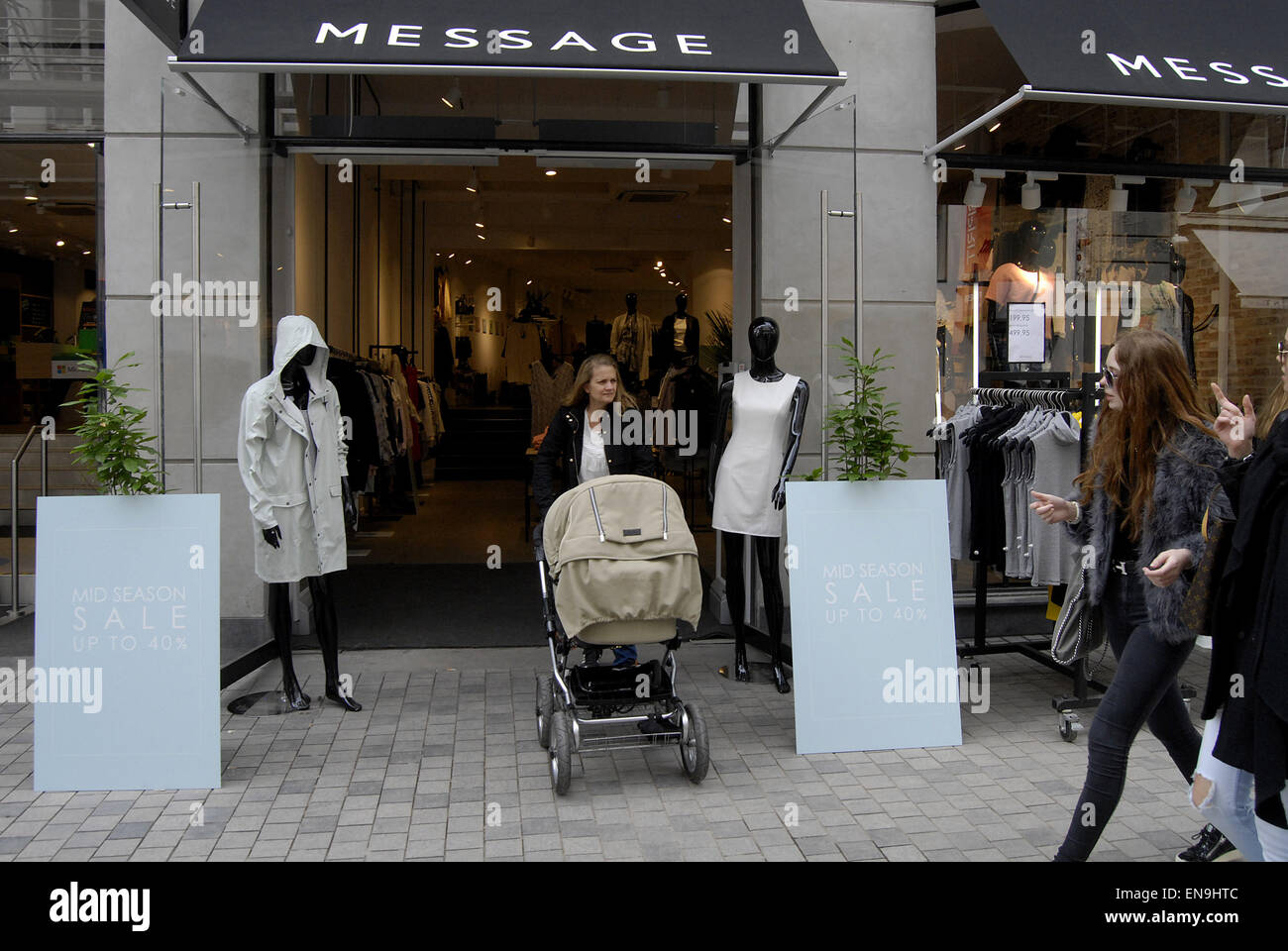 Copenhagen, Denmark. 30th April, 2015. Shoppers walk by store ads with ...