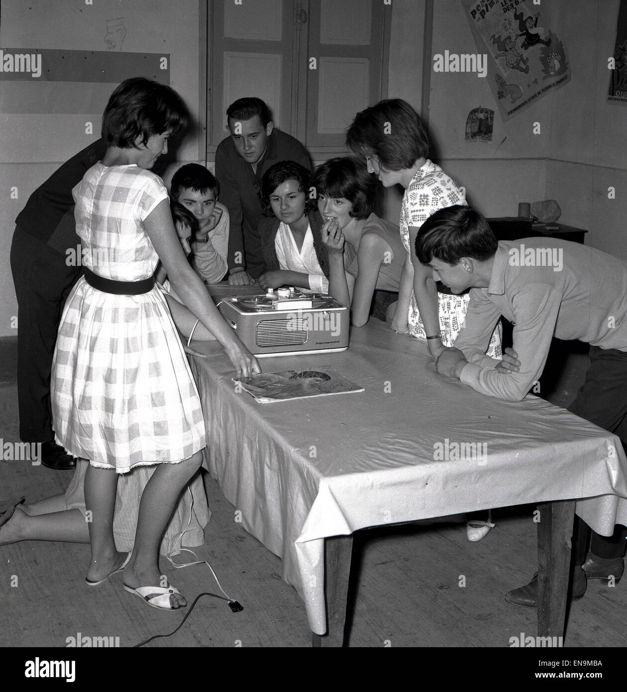 1950s, group of teenagers gather around table to listen to music from a ...