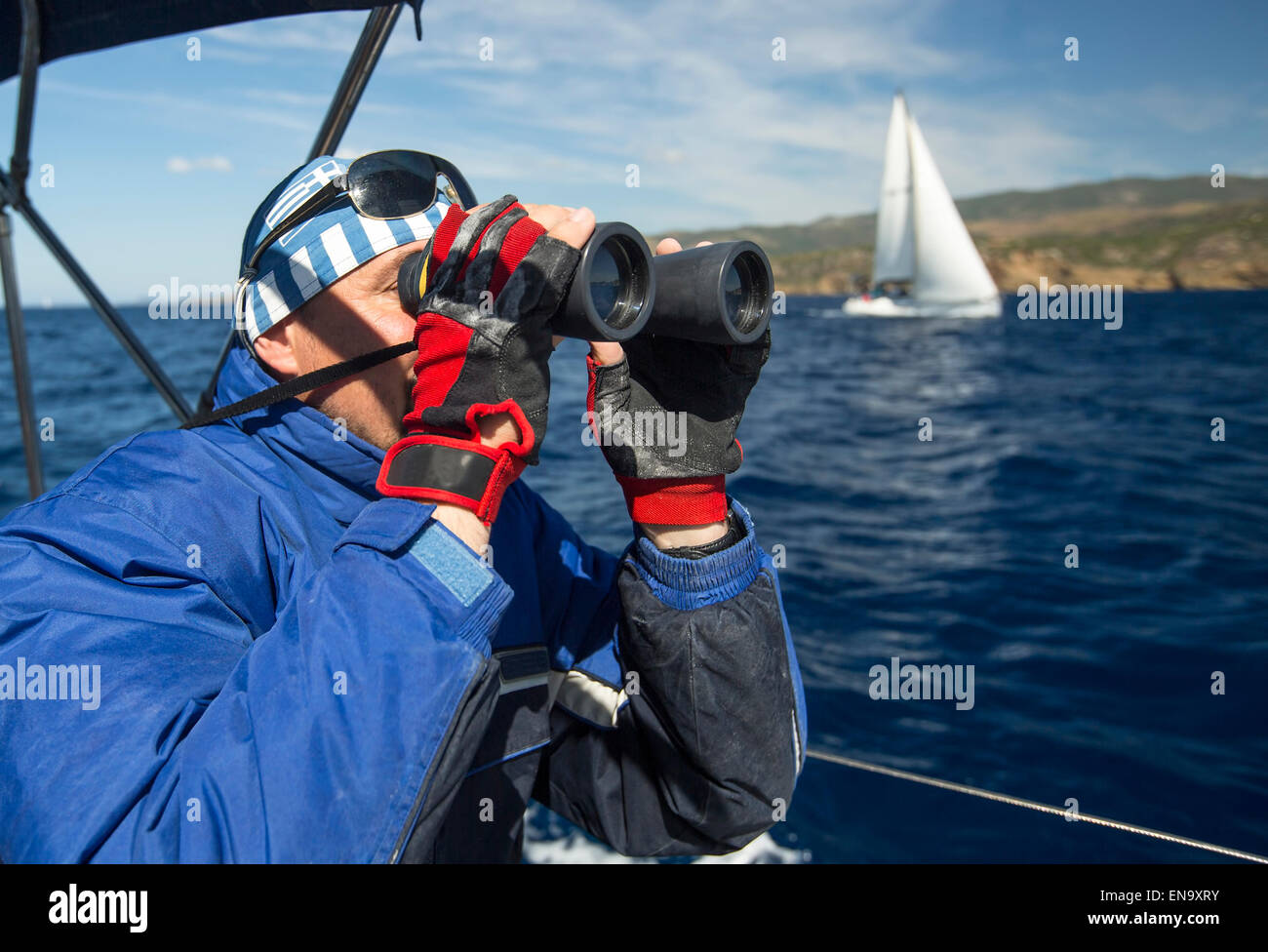Greek skipper looks through binoculars on his yacht Stock Photo - Alamy