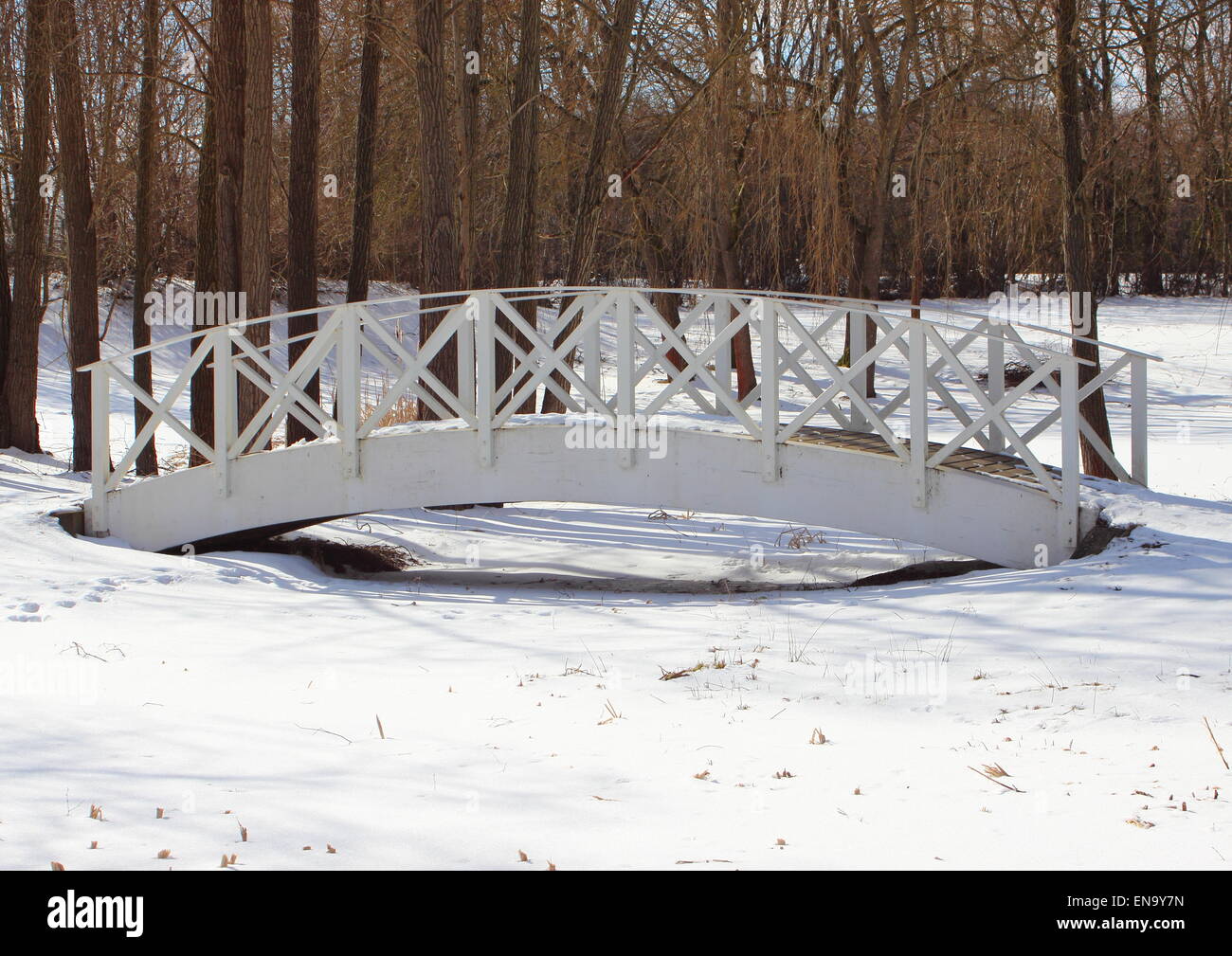 Wooden white bridge over snowy frozen water Stock Photo - Alamy