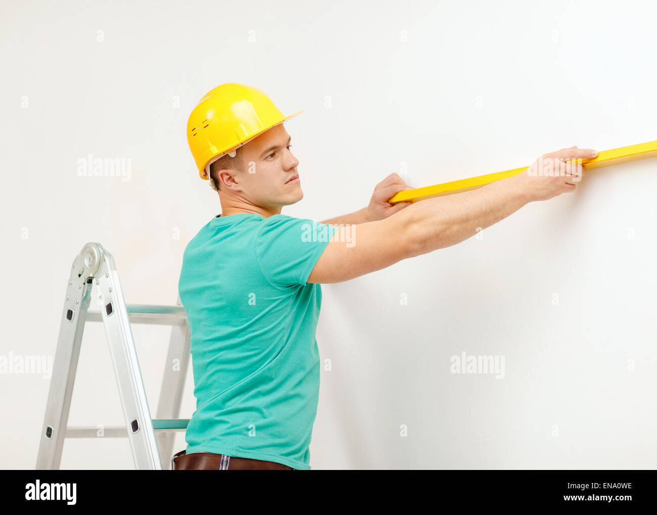 smiling man building using spirit level to measure Stock Photo - Alamy