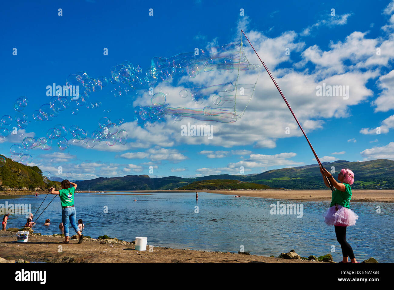 Two women creating some huge and amazing bubbles to entertain the crowd ...