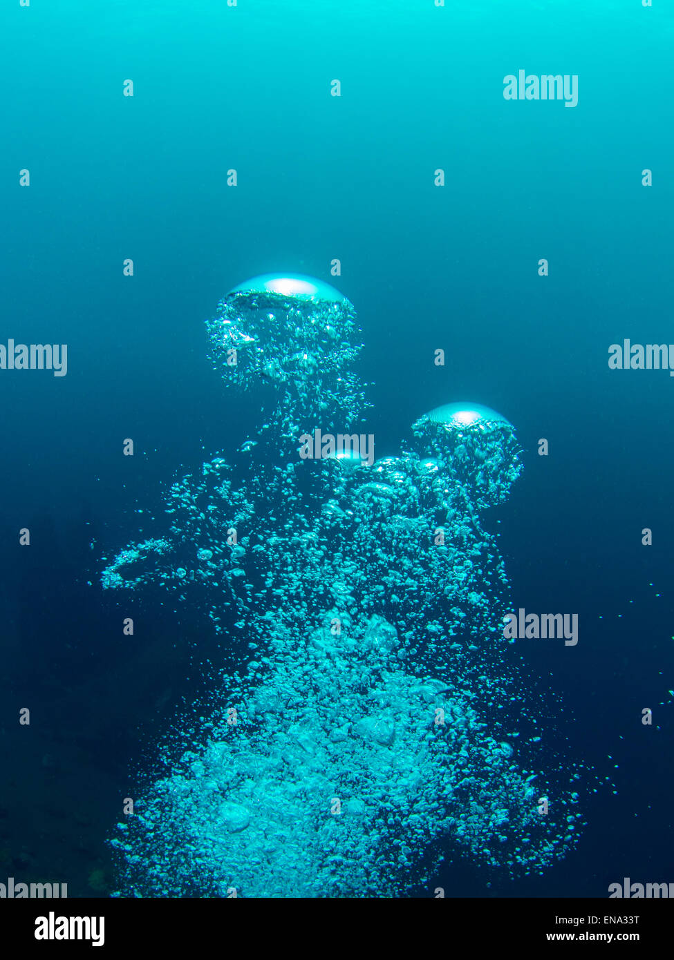 Bubbles from a SCUBA diver slowly rise to the surface, expanding and ...