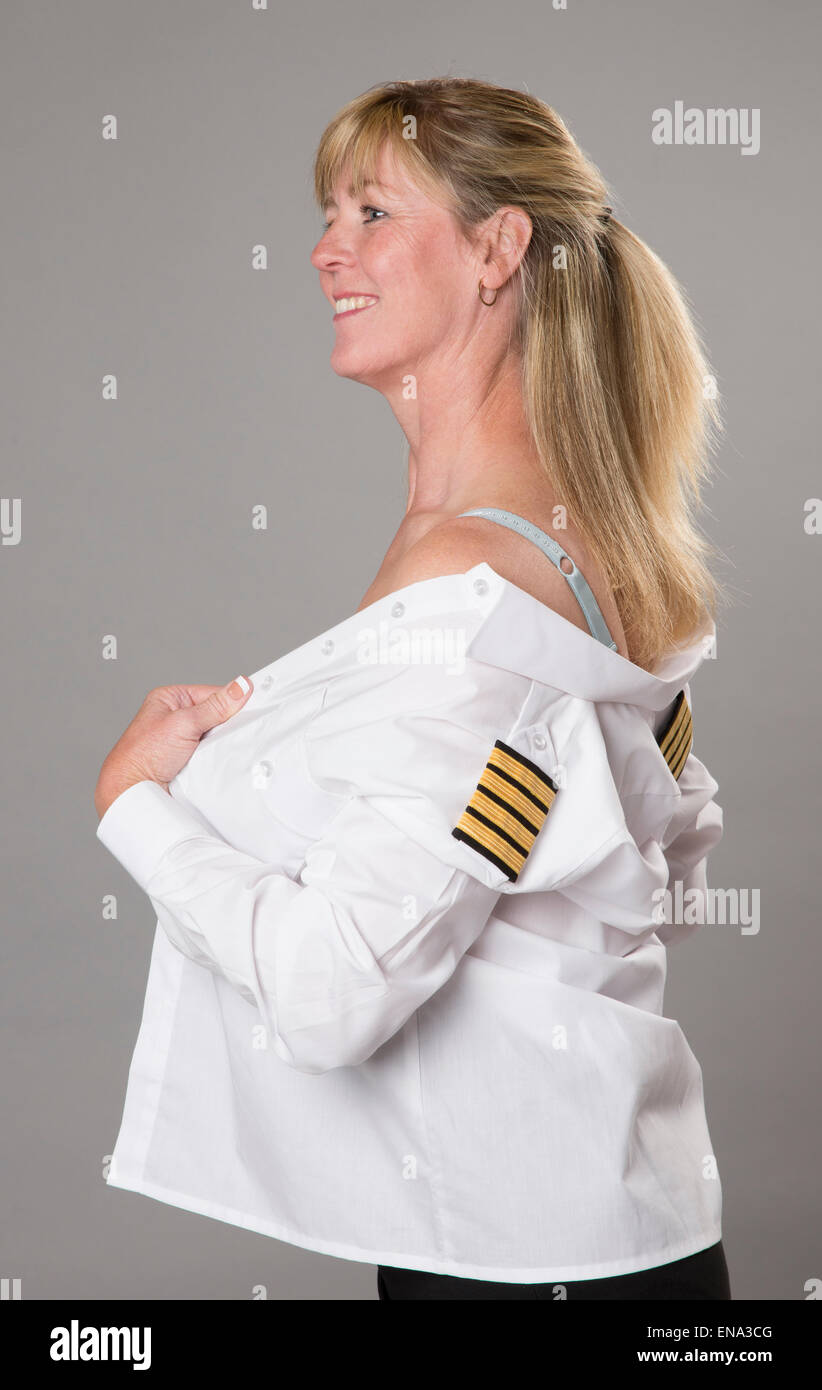 Female airline officer getting dressed into a white uniform shirt with ...