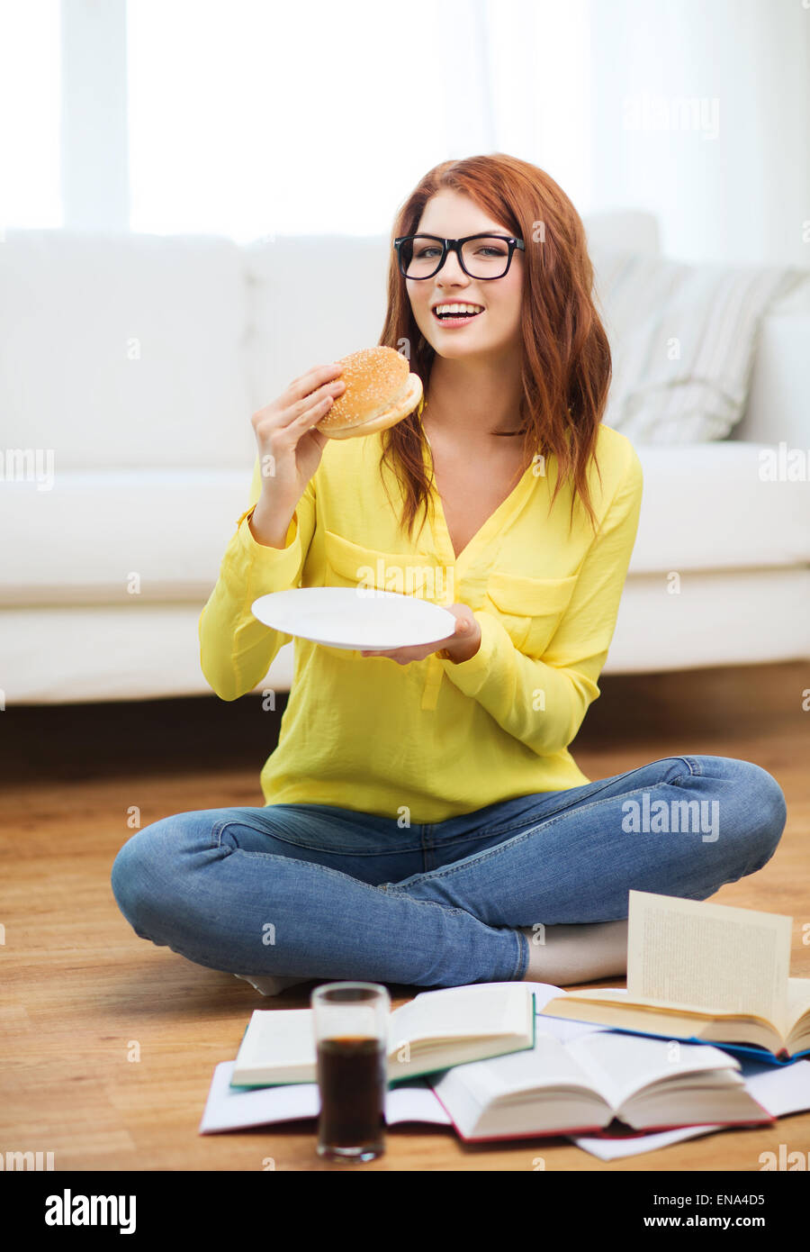 student eating hamburger and doing homework Stock Photo - Alamy