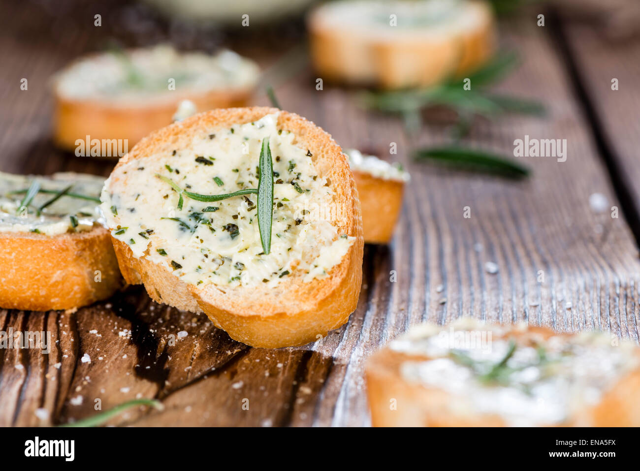 Baguette with Herb Butter and Rosemary on rustic wooden background ...